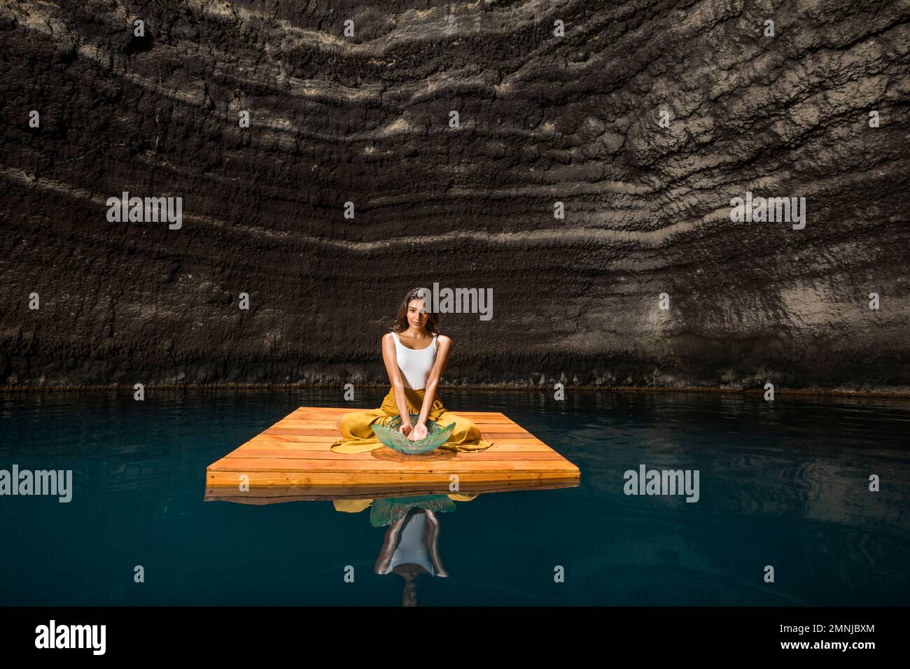 Woman sitting on wooden raft in cenote Stock Photo - Alamy