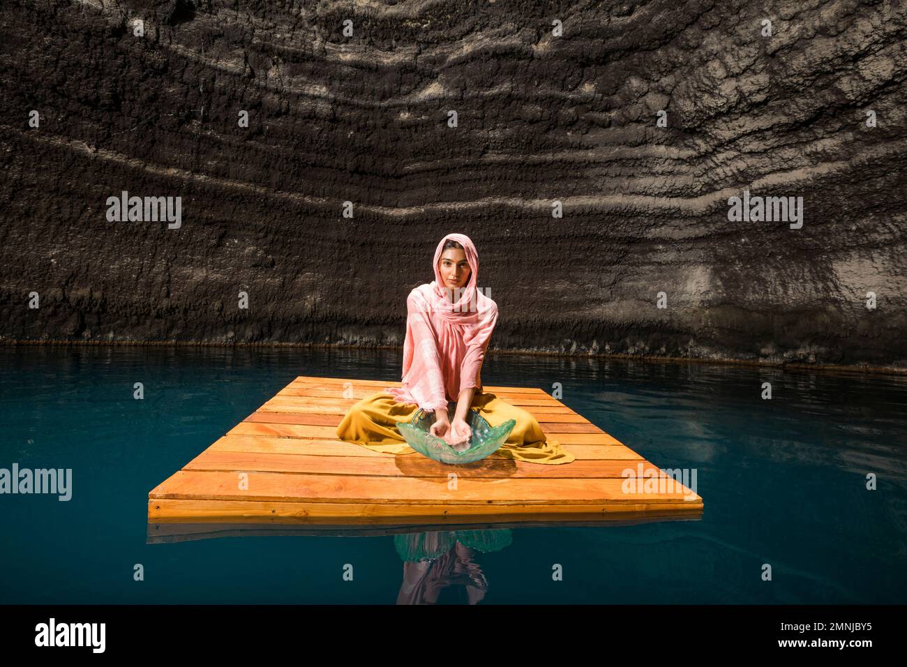 Woman sitting on wooden raft in cenote Stock Photo - Alamy