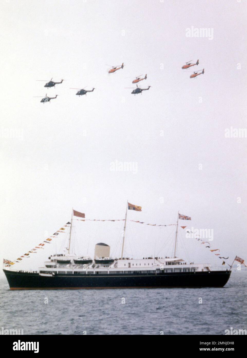 Lynx (blue) and Gazell (red) helicopters fly above the royal yacht Britannia during the Jubilee ...