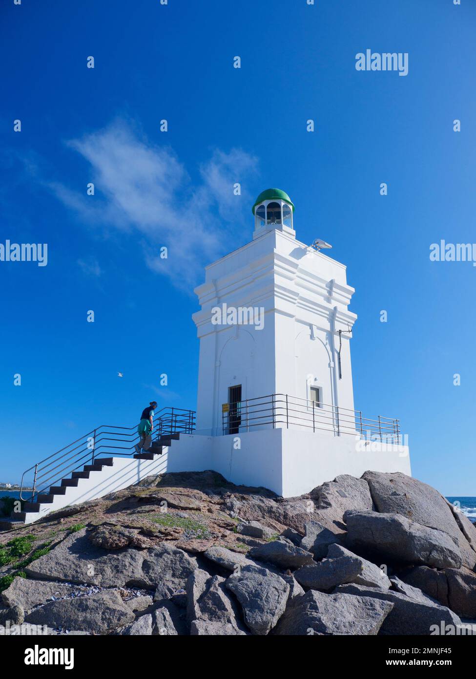 South Africa, Western Cape, St Helena, Woman climbing white lighthouse ...