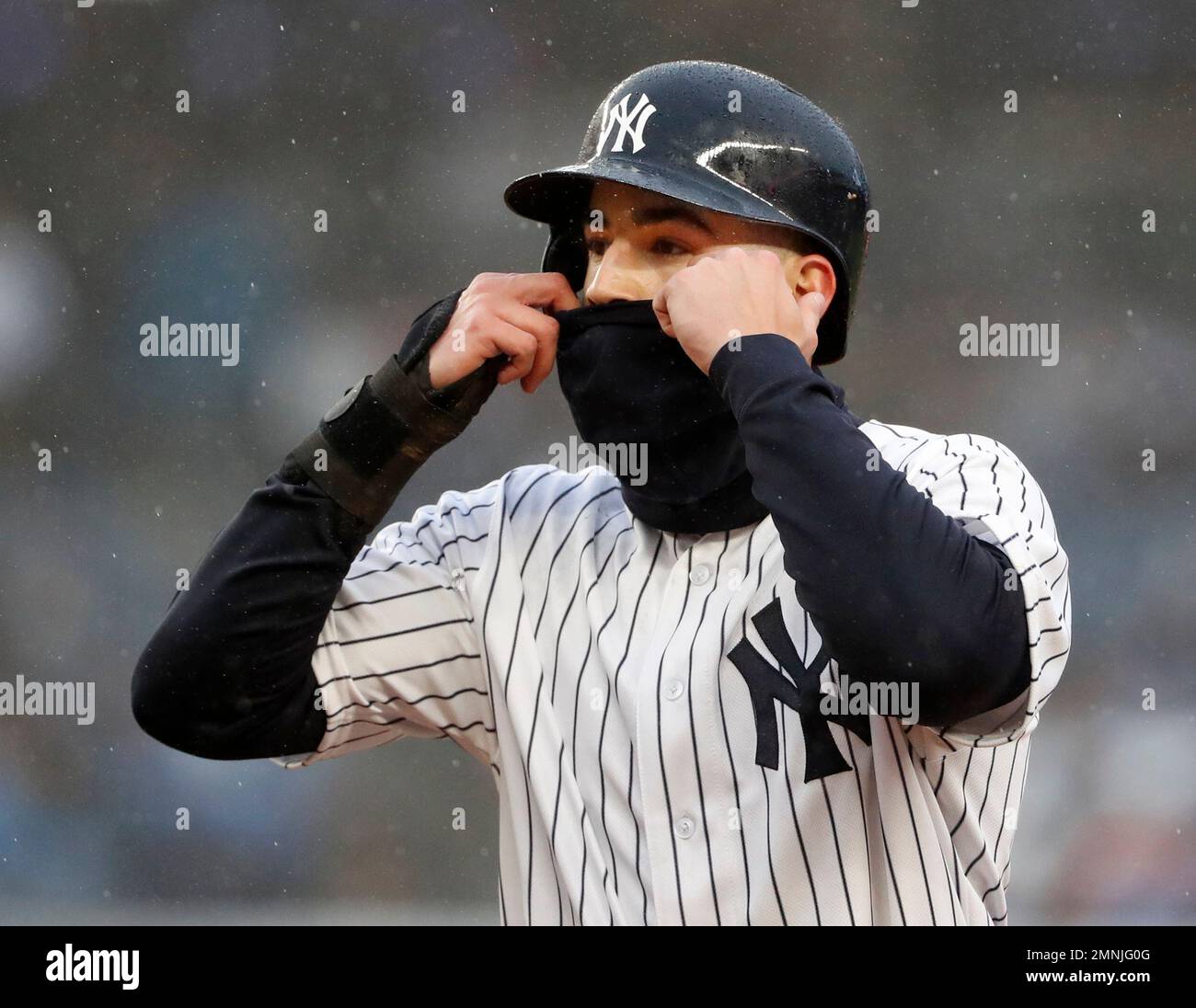 New York Yankees' Tyler Wade adjusts his neck gaiter over his face ...