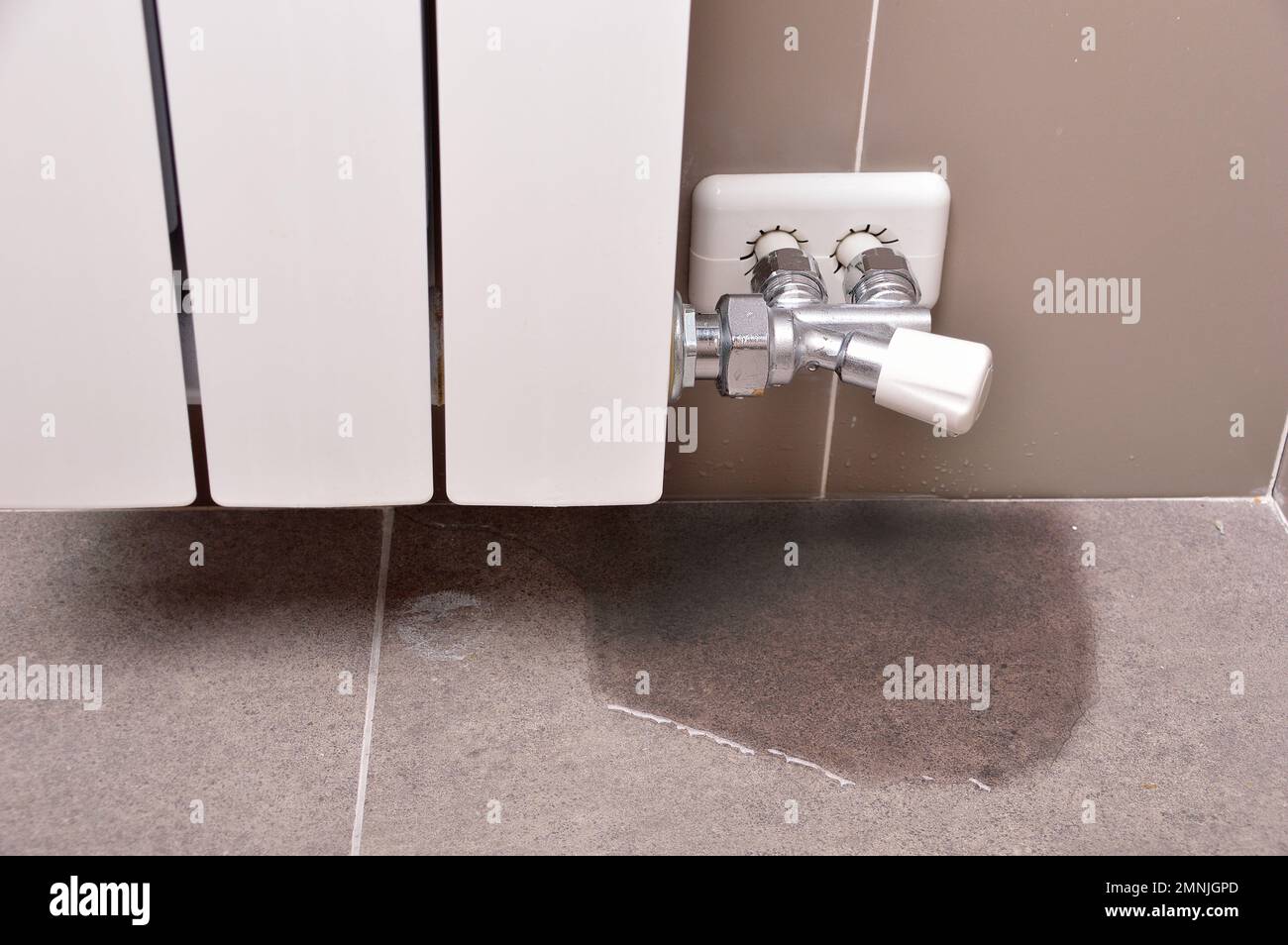 water leak through the heating radiator tube nut Stock Photo - Alamy