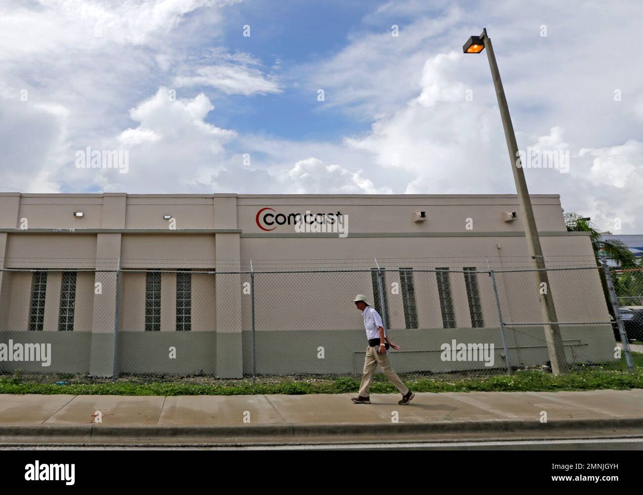 In this Oct. 12, 2017, photo a pedestrian walks by a Comcast Service ...