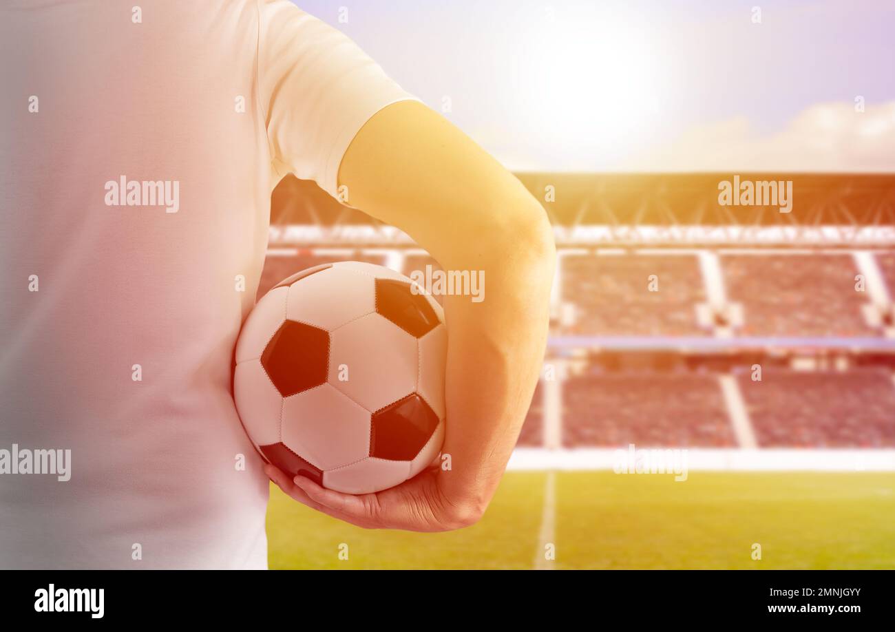 Cropped Rearview Image Of A Young Player Man Holding A Soccer Ball Under His Arms At The Stadium