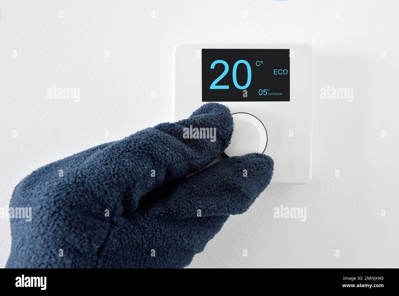 One hand with glove adjust thermostat digital in celsius at home Stock ...