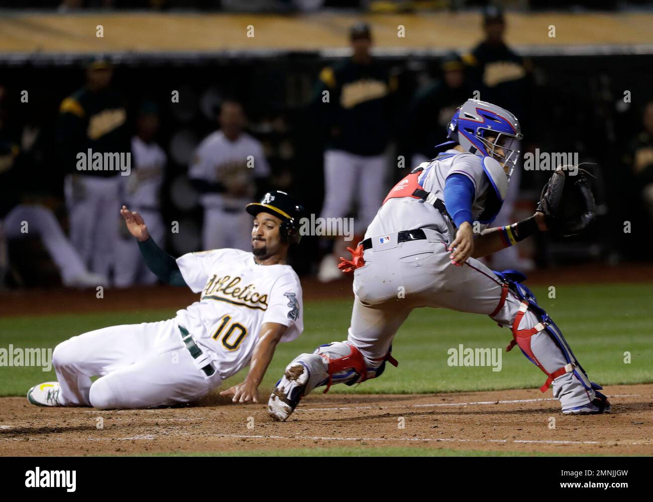 Oakland Athletics' Marcus Semien (10) scores past Texas Rangers catcher ...