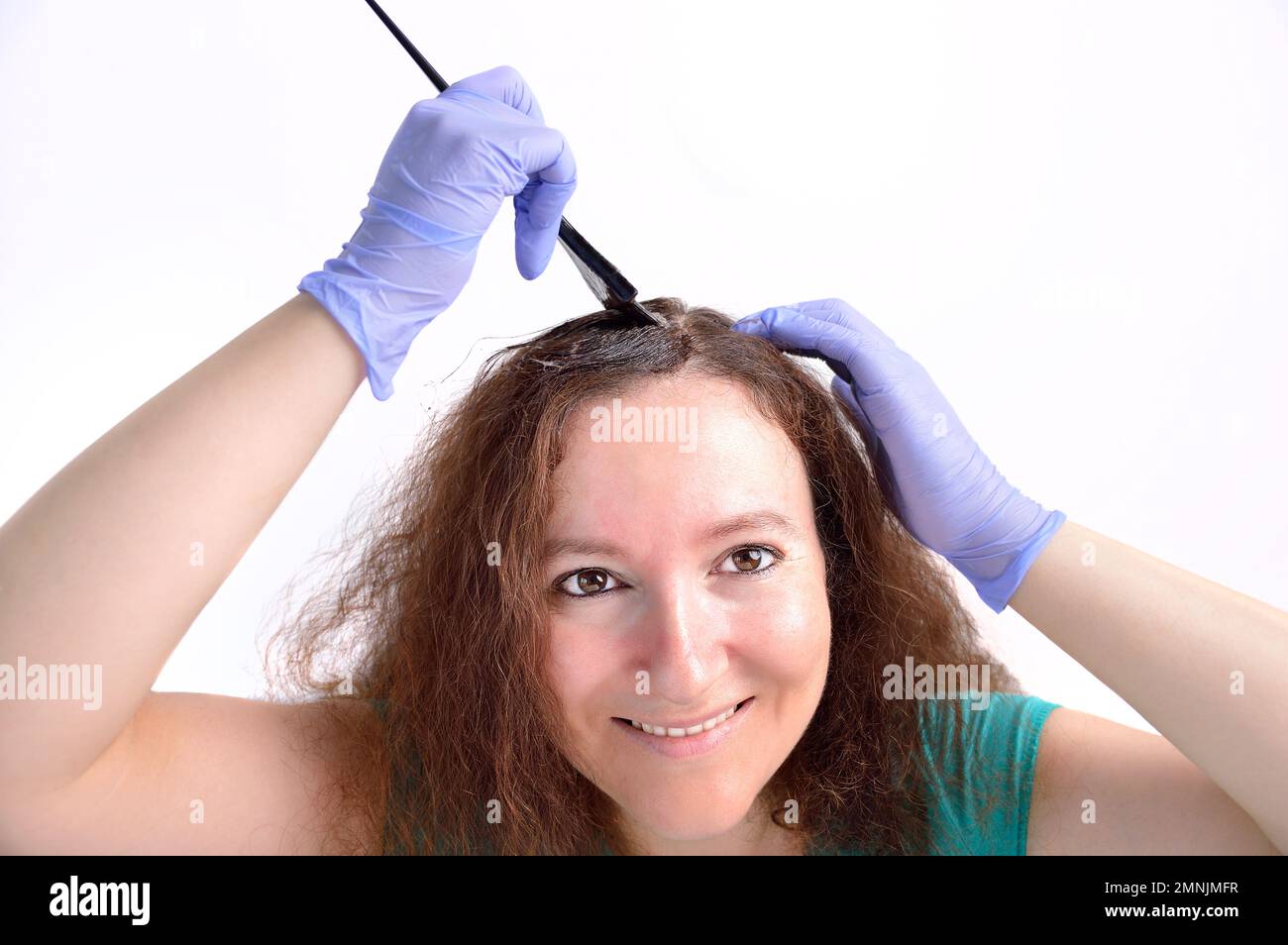 Brunette woman dying her hair with white background Stock Photo - Alamy