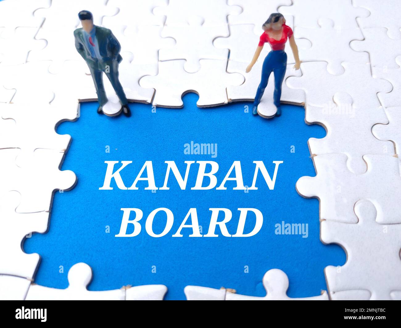 Miniature people with the word KANBAN BOARD on a blue white puzzle ...