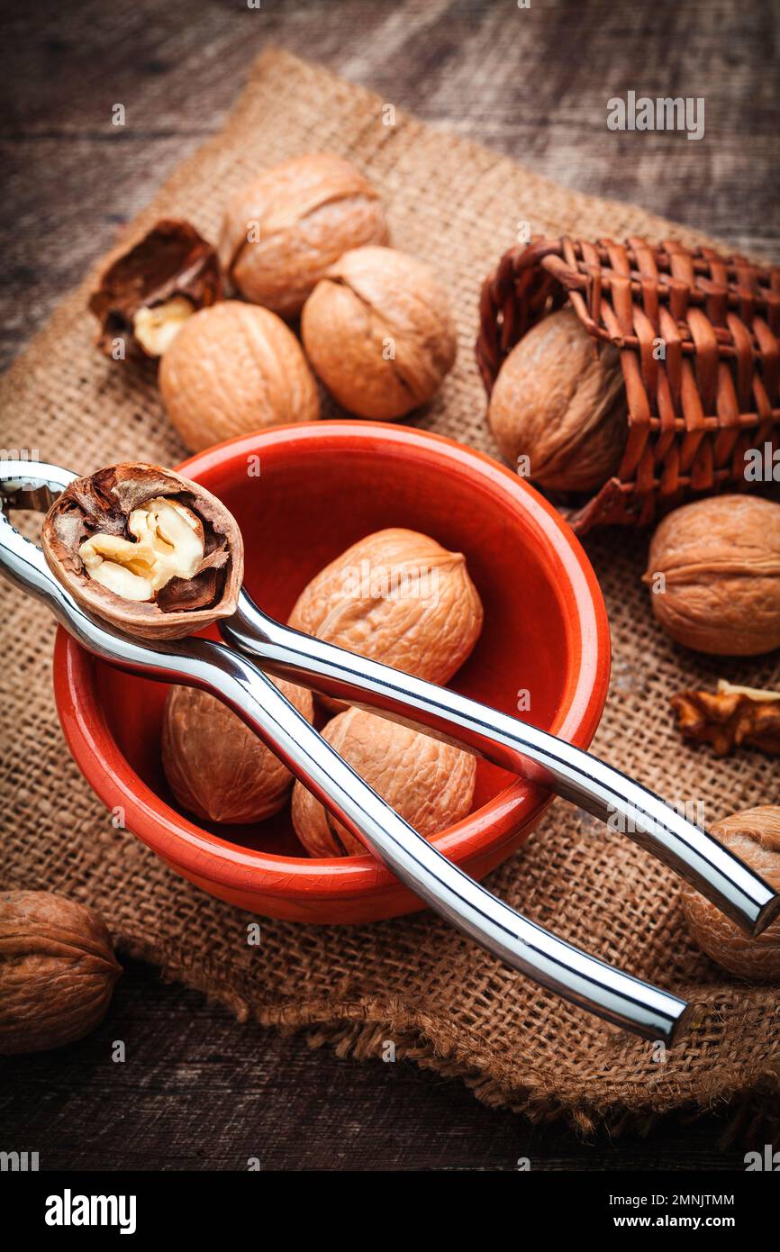 Handful of walnuts on a sheet of burlap with the shell broken and ...