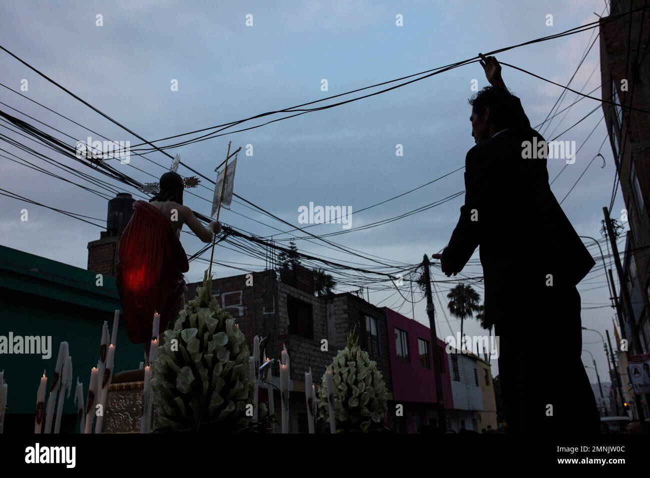 A man lifts an electricity cable so that the image of Jesus Christ can ...