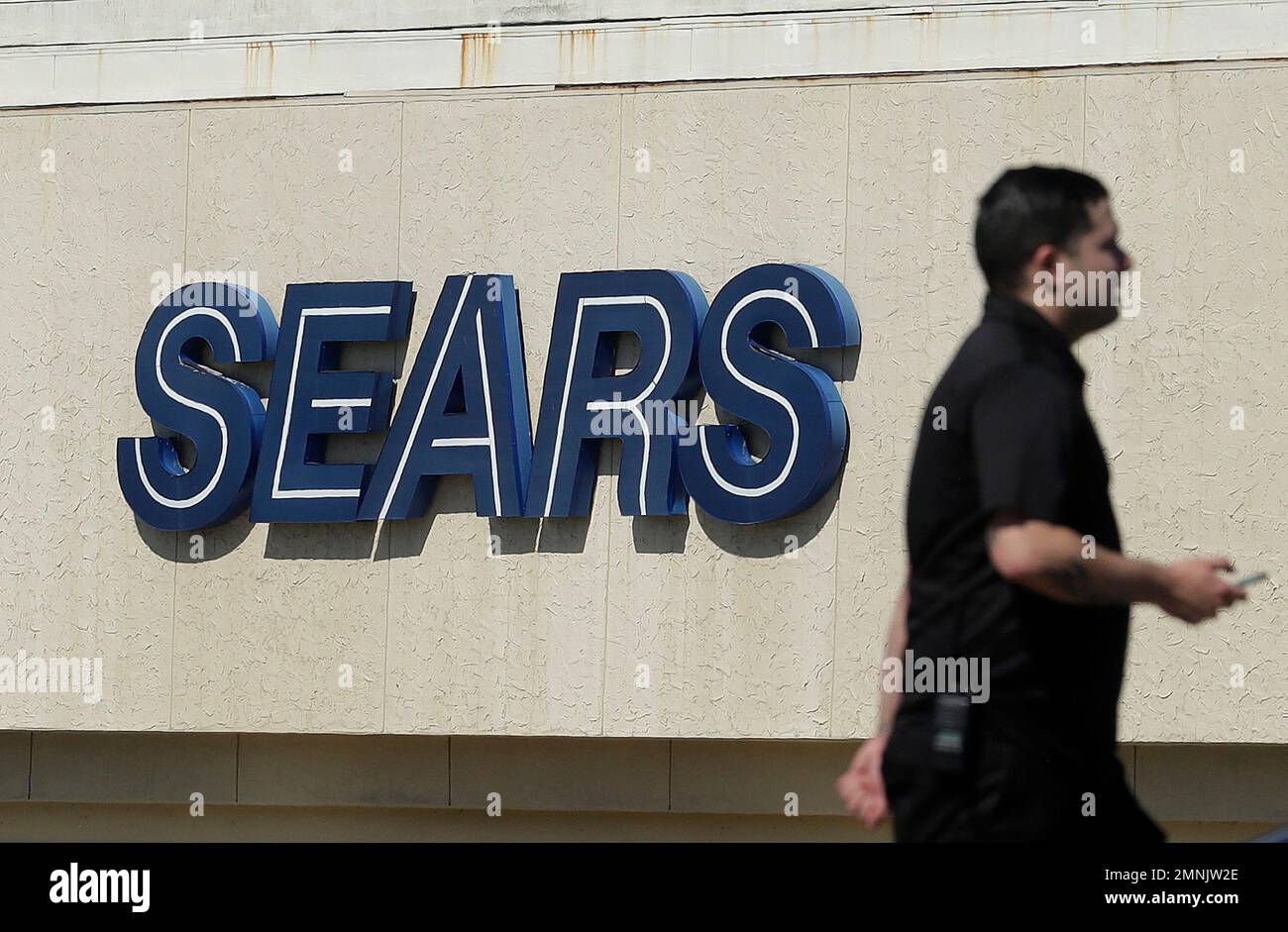 In this March 28, 2018 photo, a man walks in front of a Sears sign in ...