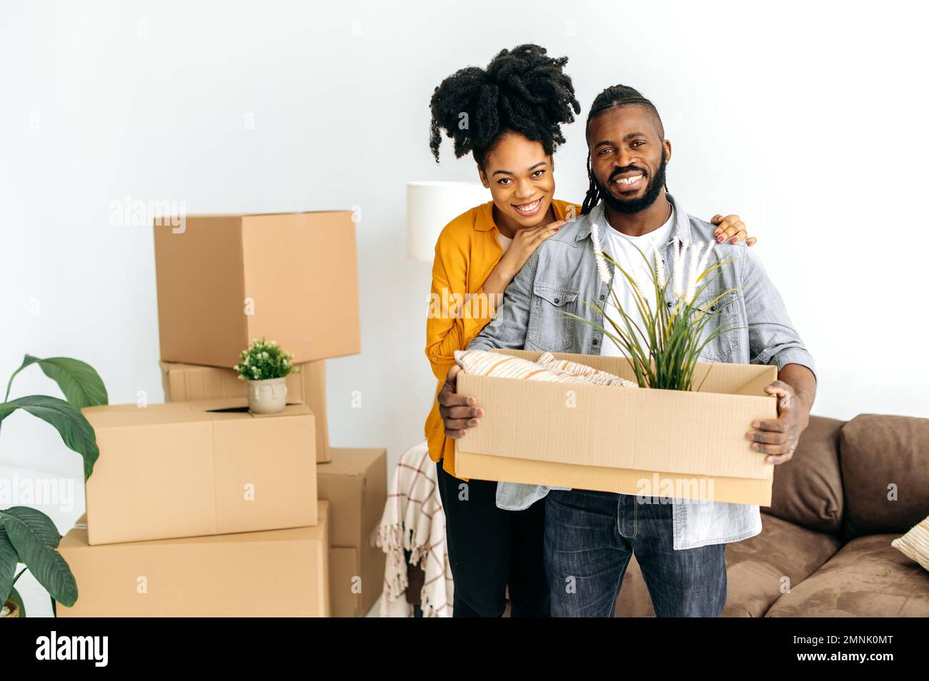 Joyful african american spouses, moving into a new apartment, standing ...