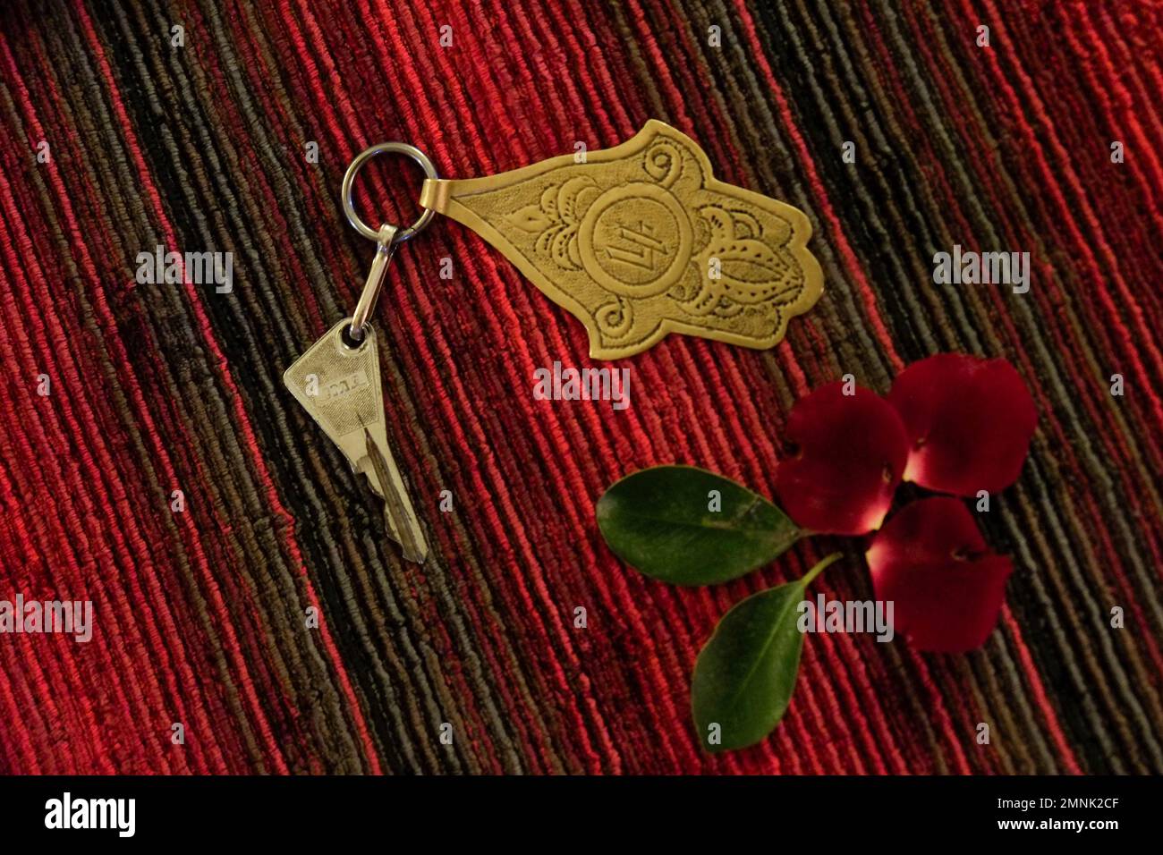 Brass room key and flower Stock Photo - Alamy