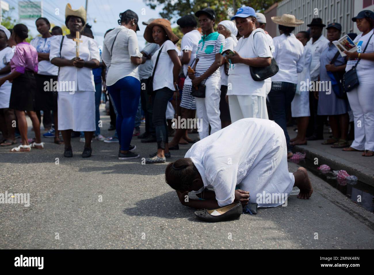 A woman prostrates during a Way of the Cross procession marking Good ...