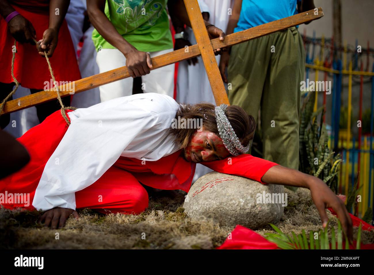A man playing the role of Jesus Christ performs the third fall of Jesus ...