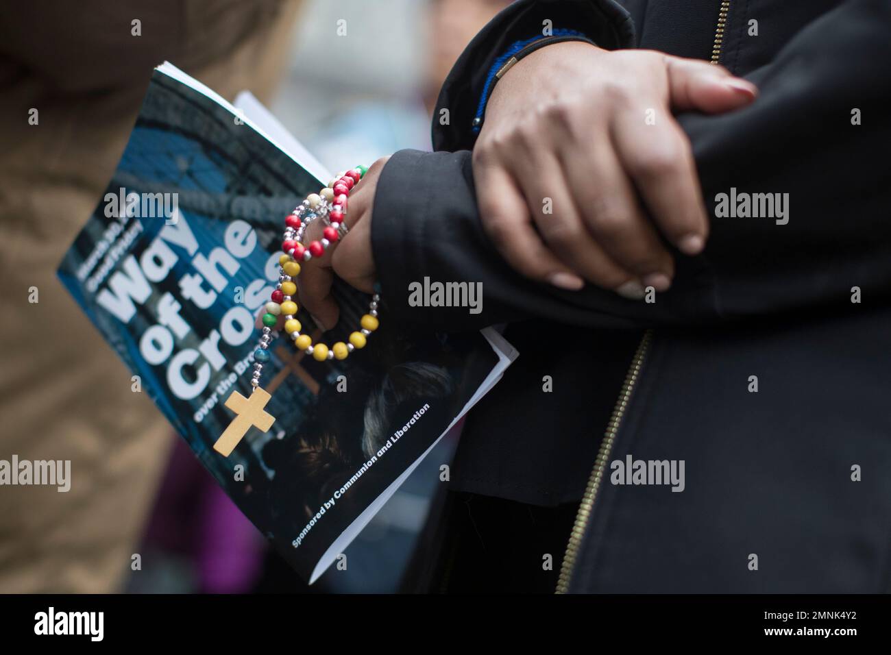 A congregant holds a rosary as she pauses in prayer during a Stations ...