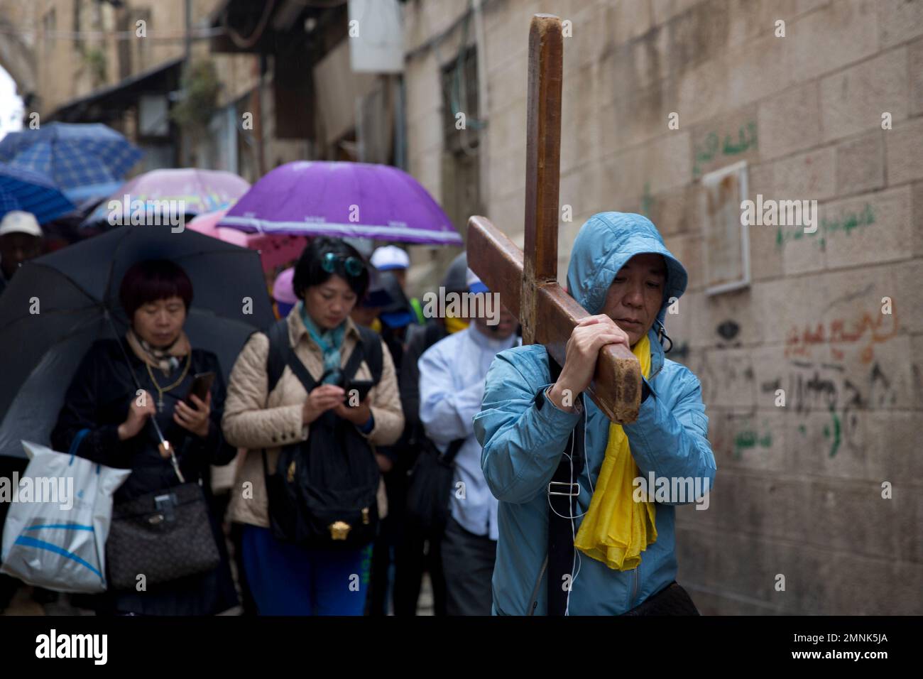 Christian worshippers hold a cross as they walk along the Via Dolorosa ...