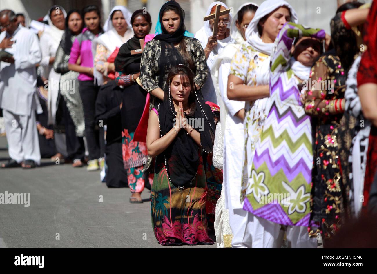 An Indian Christian devotee kneels to pray during a procession to mark ...