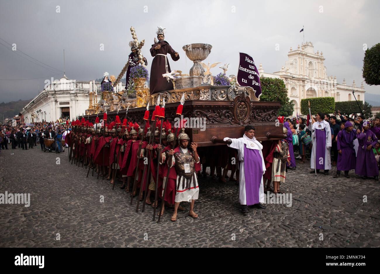 Men dressed as Roman soldiers carry a religious float with a statue of ...