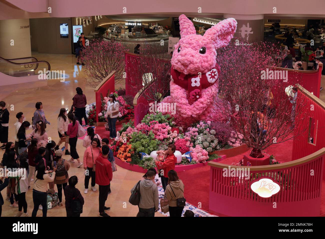Shoppers pose in front of a "Year of the Rabbit" Lunar New Year display ...