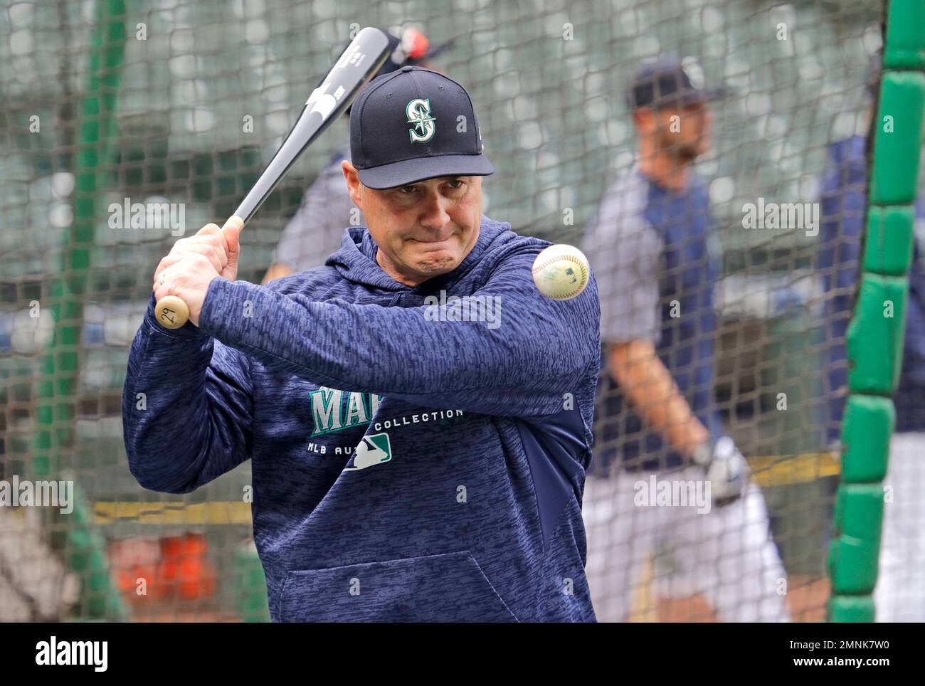 Seattle Mariners manager Scott Servais hits a ball to players as they ...