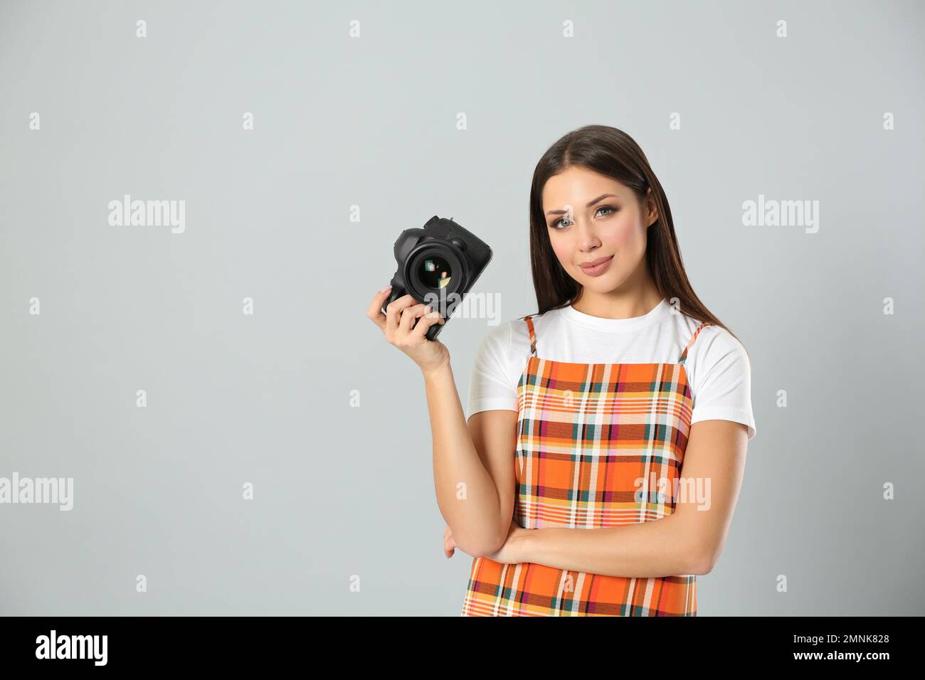 Professional photographer working on light grey background in studio ...