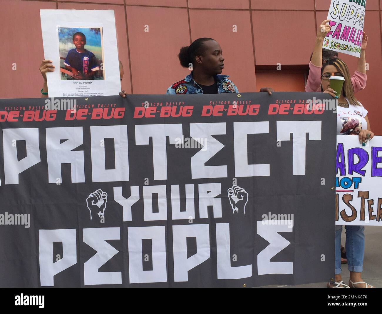 Demonstrators banners during a protest in Compton, Calif., Thursday ...