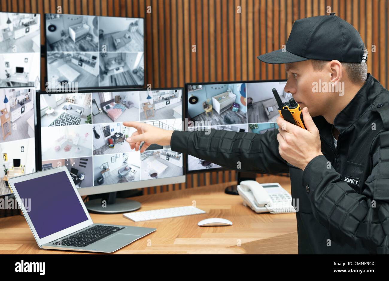 Security guard with portable transmitter monitoring modern CCTV cameras ...