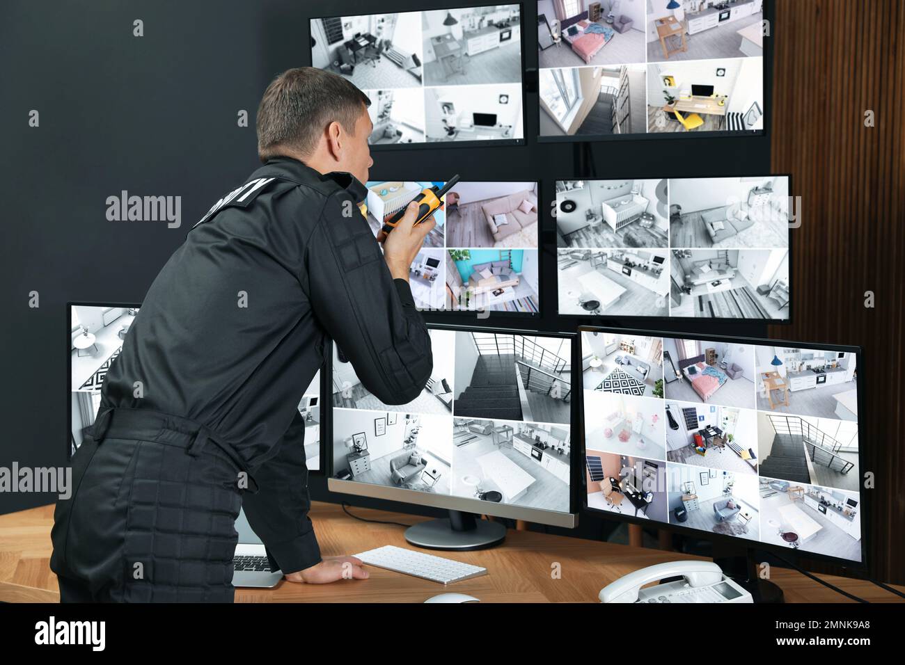 Security guard with portable transmitter monitoring modern CCTV cameras ...