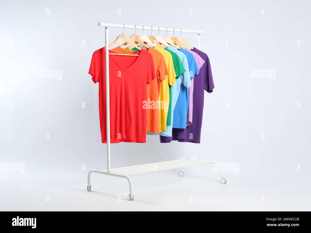 Colorful clothes hanging on rack against white background Stock Photo ...