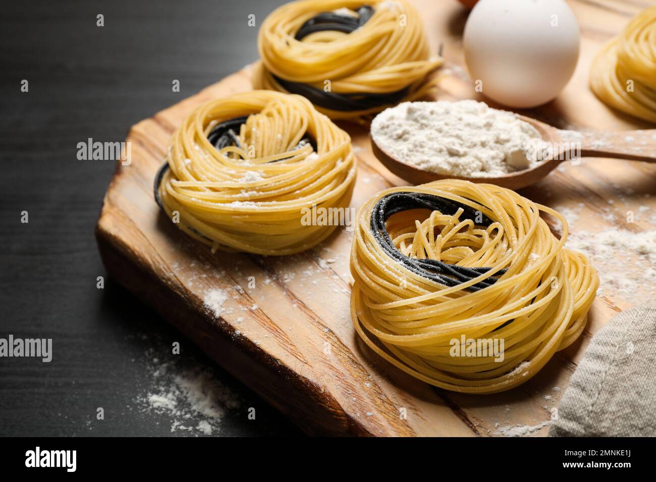 Raw linguine pasta on black wooden table, closeup Stock Photo - Alamy