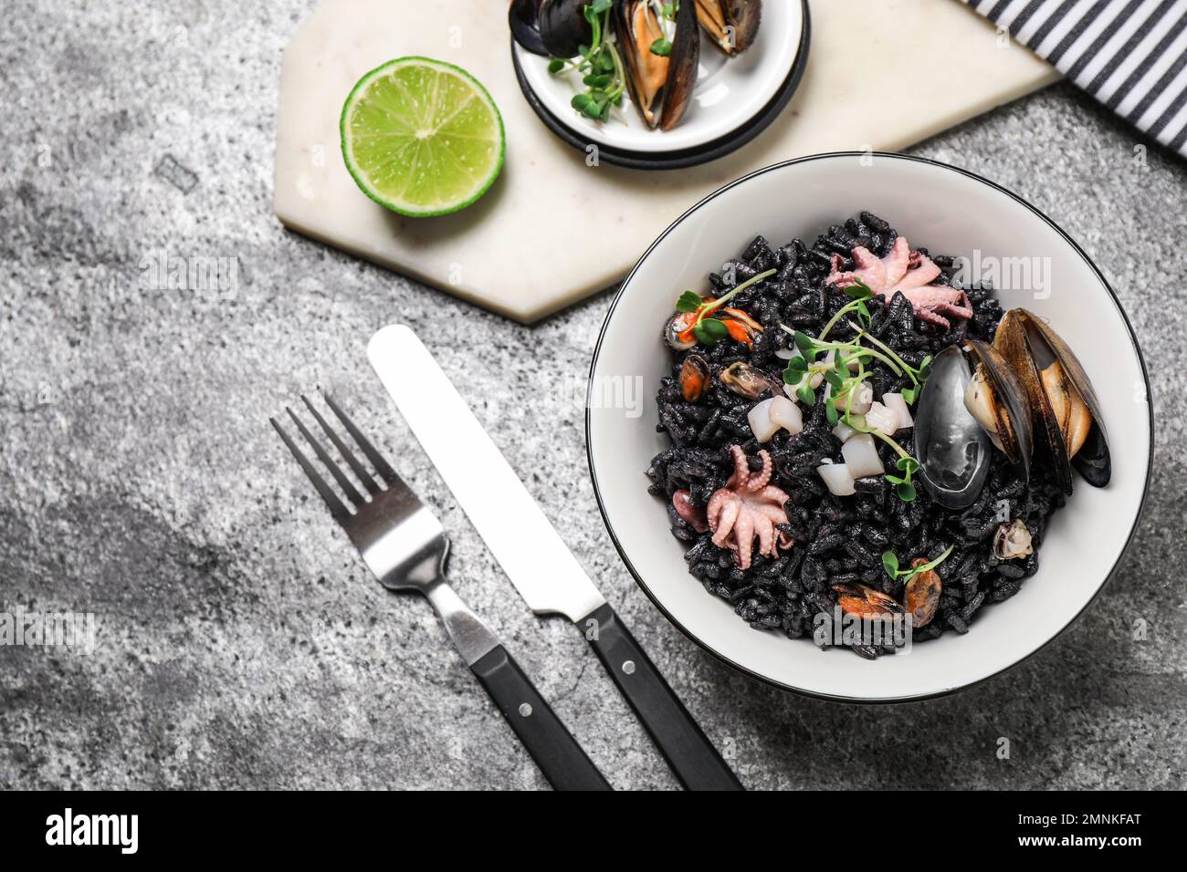 Delicious black risotto with seafood served on light grey table Stock ...
