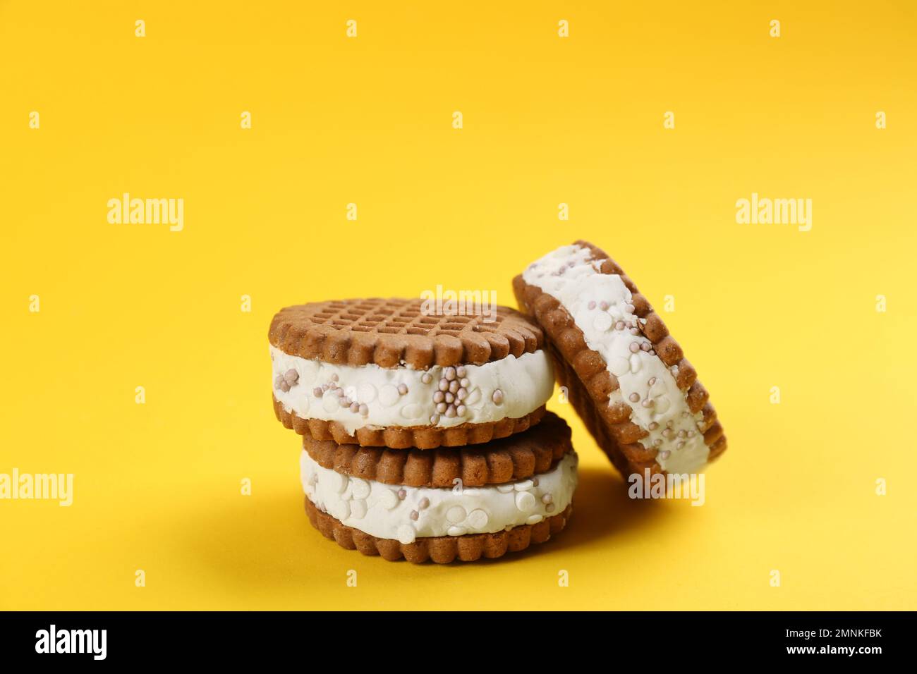 Sweet delicious ice cream cookie sandwiches on yellow background Stock ...
