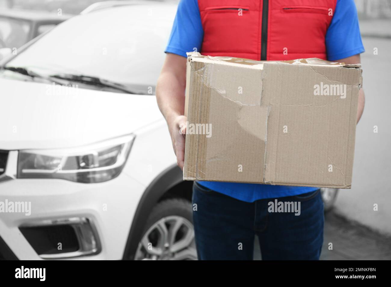 Courier with damaged cardboard box outdoors, closeup. Poor quality ...