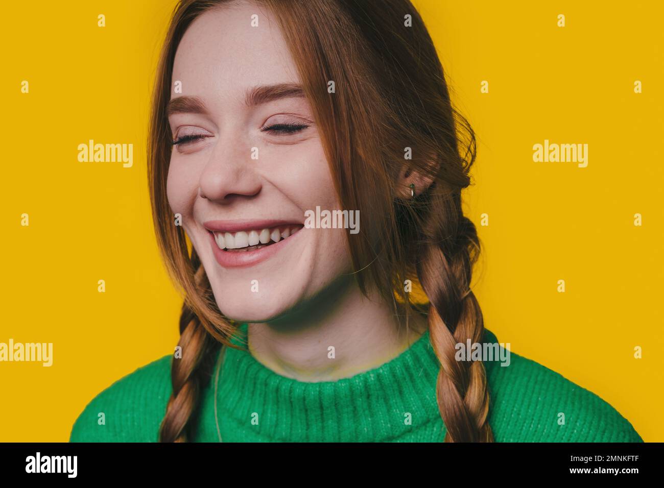 Positive ginger woman with natural freckles, long hair posing in studio ...