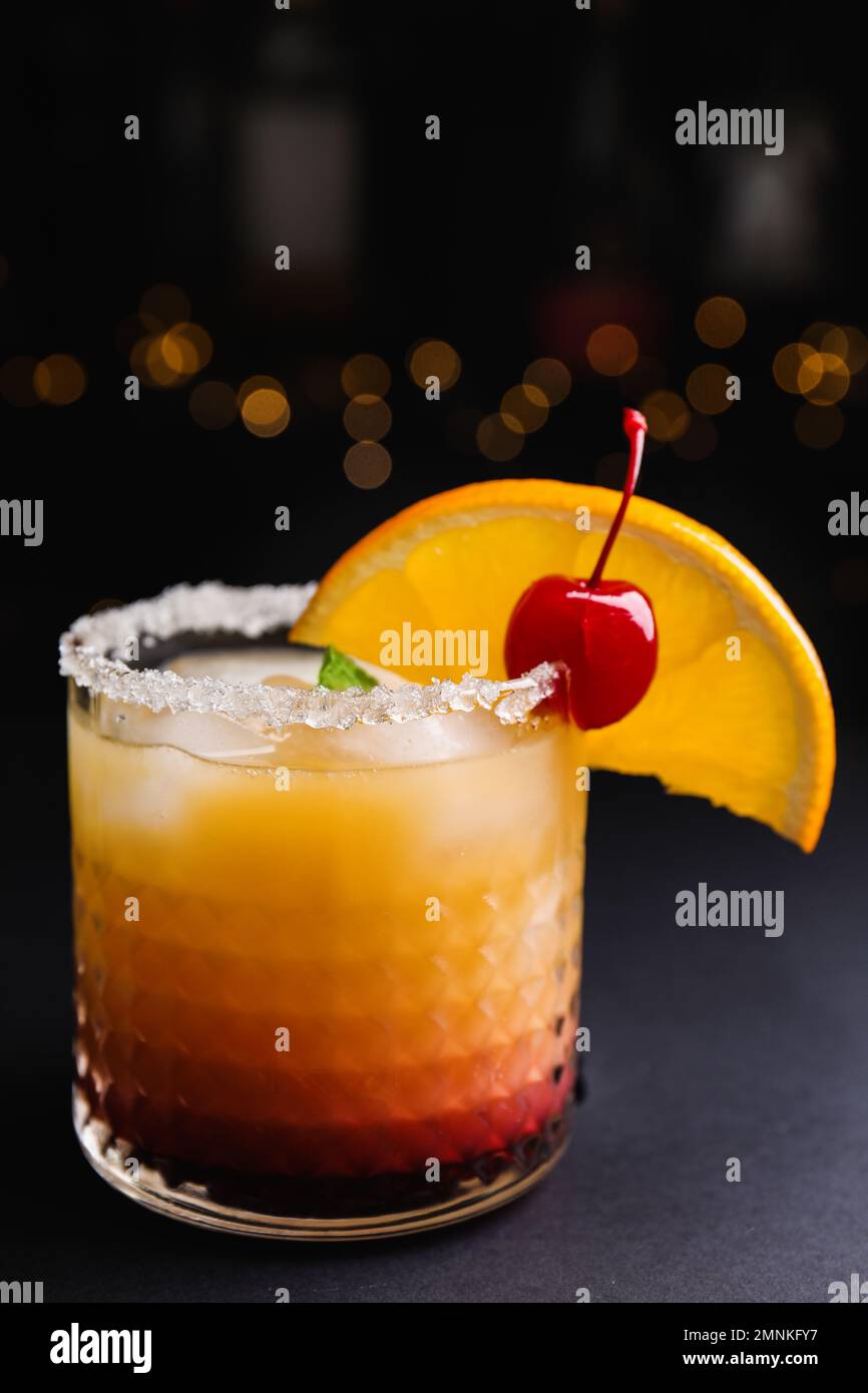Fresh alcoholic Tequila Sunrise cocktail on black table Stock Photo - Alamy