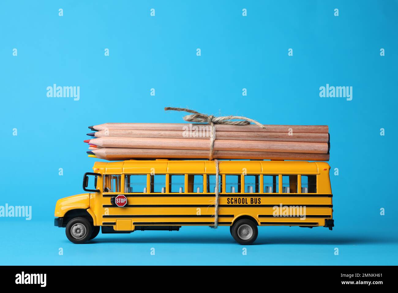 School bus model with color pencils on light blue background. Transport ...