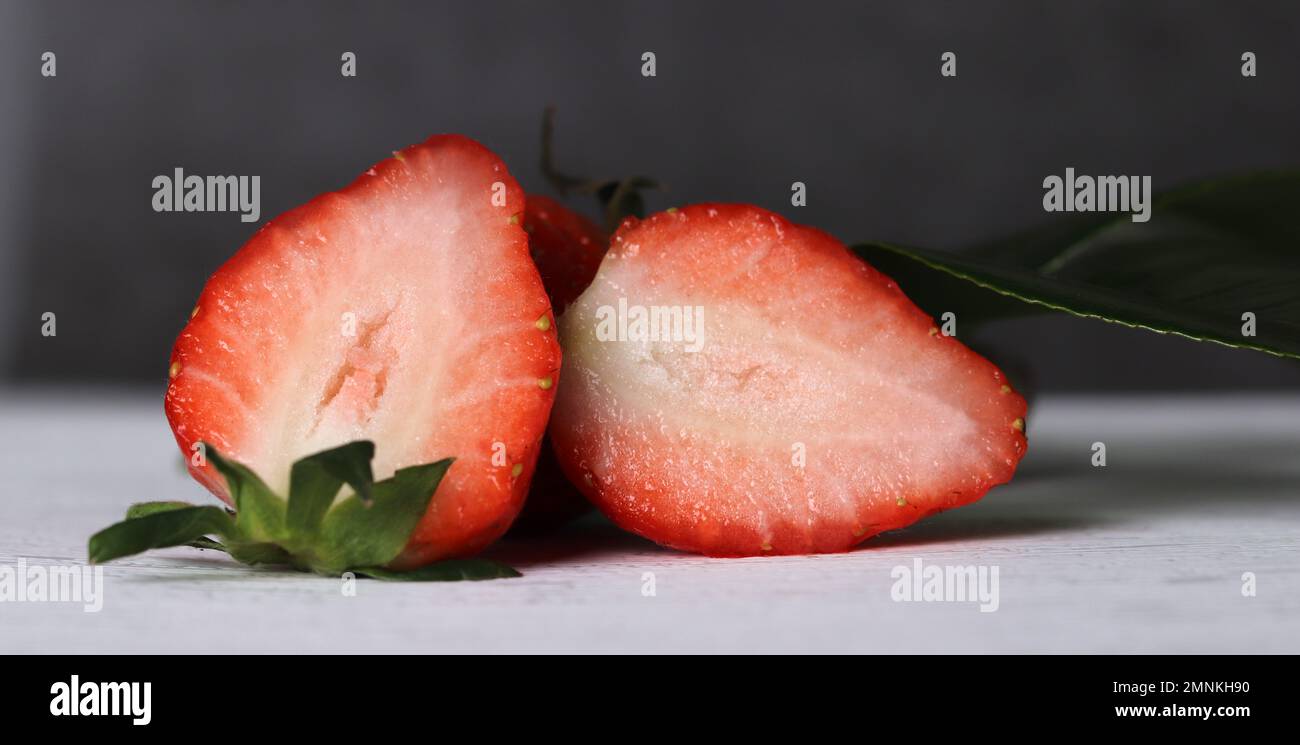 Close-up image of a fresh strawberry cut in half. Fresh fruits that are ...