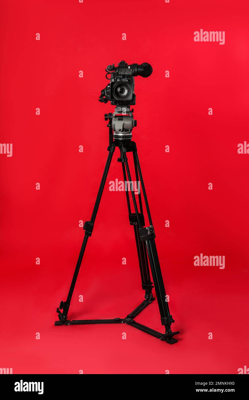 Modern professional video camera on red background Stock Photo - Alamy