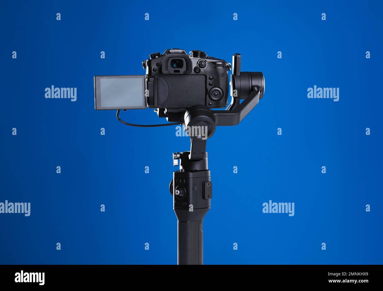 Modern professional video camera on blue background Stock Photo - Alamy