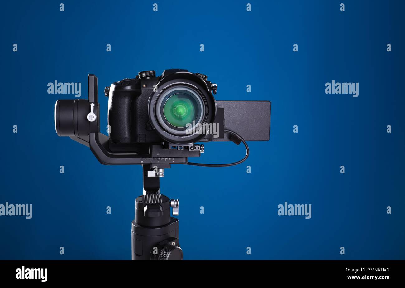 Modern professional video camera on blue background Stock Photo - Alamy