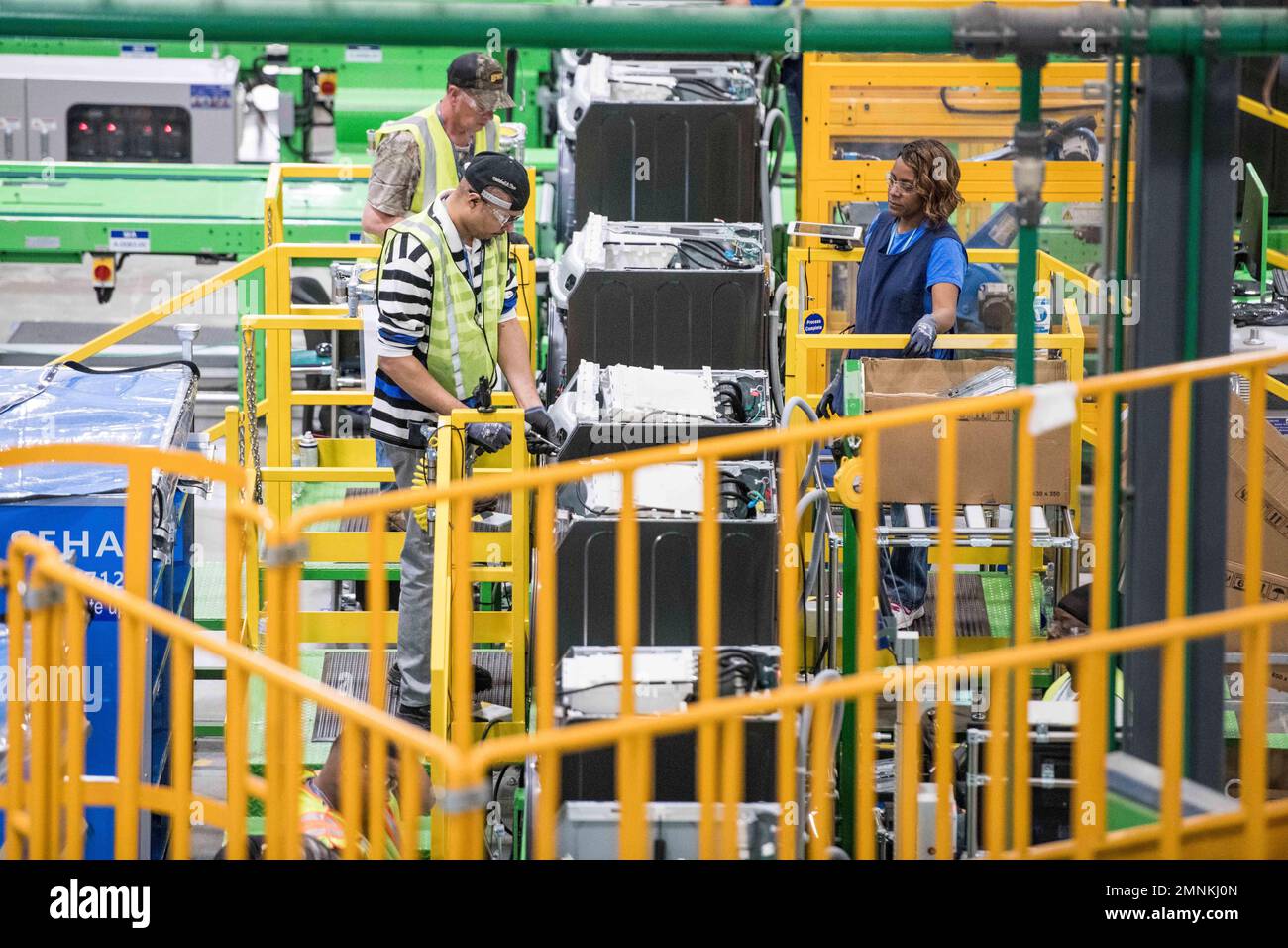 Workers build washing machines on the assembly line at the Samsung ...