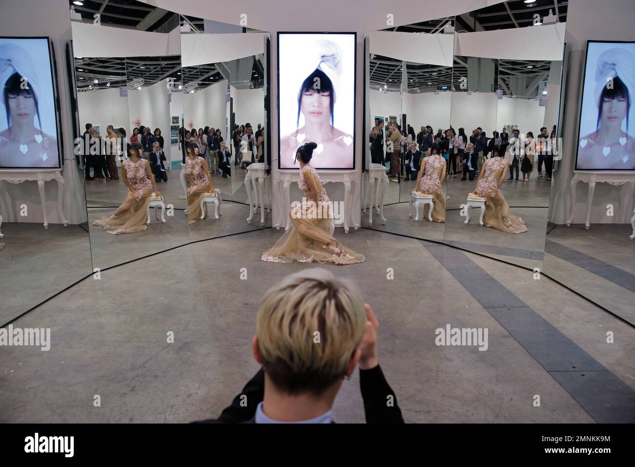 A performer sits in an art installation created by the Qatari-American ...