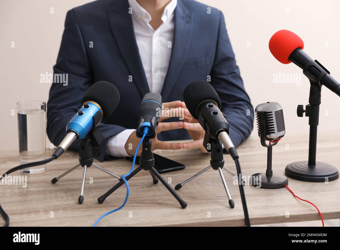 Businessman giving interview at table with microphones, closeup ...