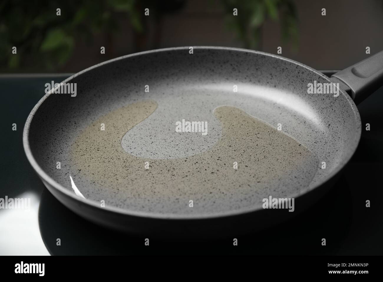 Frying pan with cooking oil on induction stove Stock Photo - Alamy