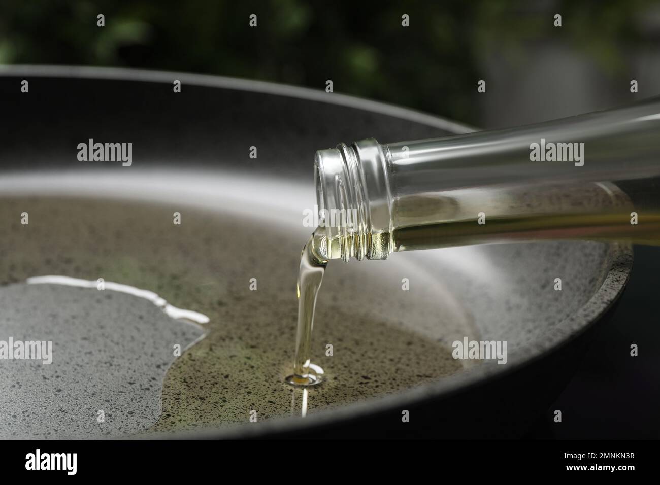 Pouring cooking oil from bottle into frying pan, closeup Stock Photo ...