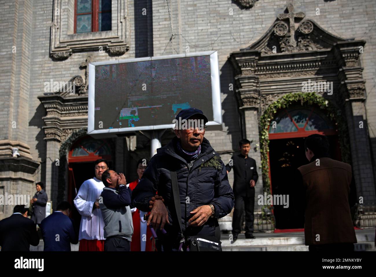 Chinese Catholics offer prayers as worshippers receive bread from a ...