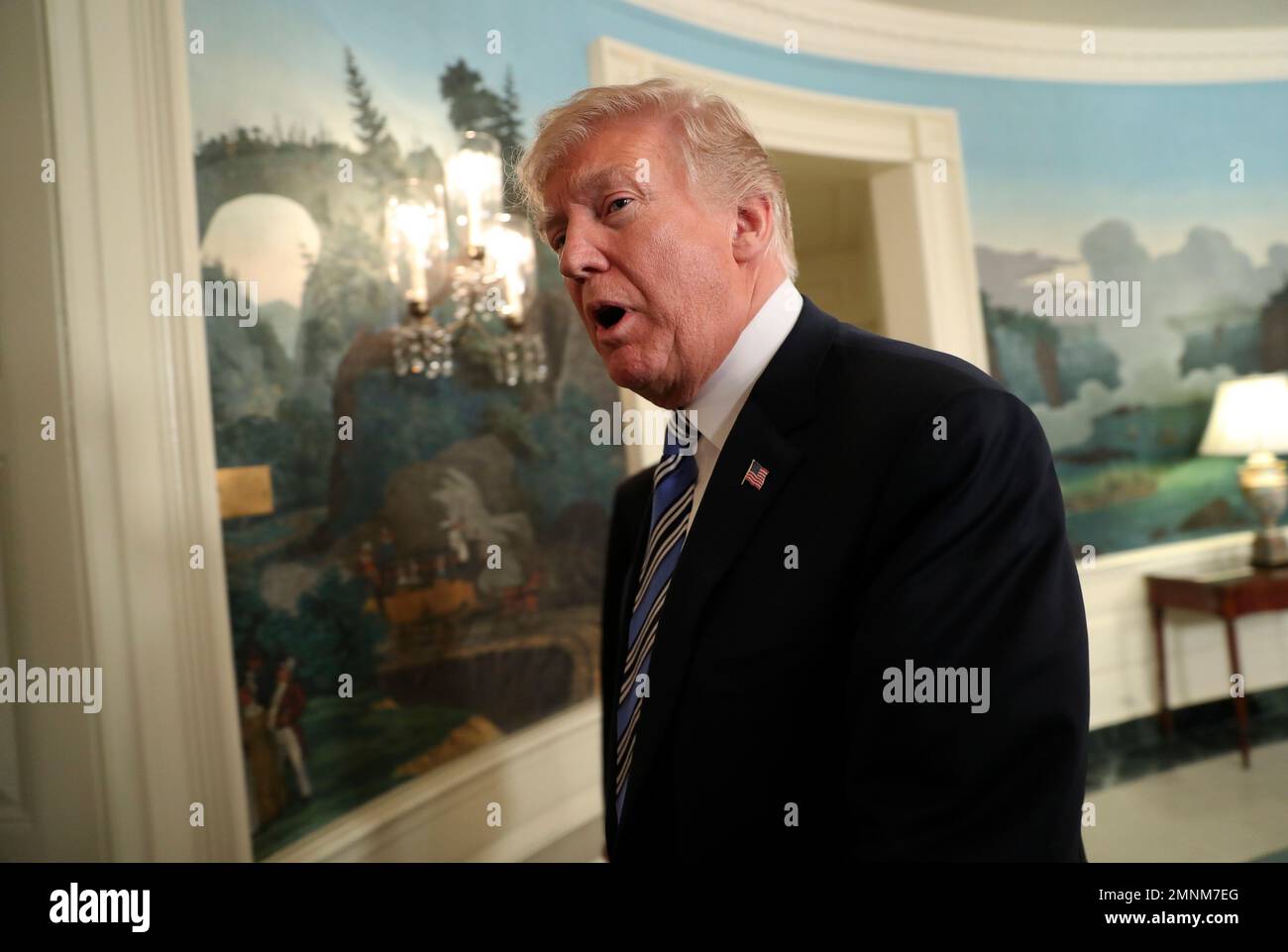 President Donald Trump walks out of the Diplomatic Room of the White ...