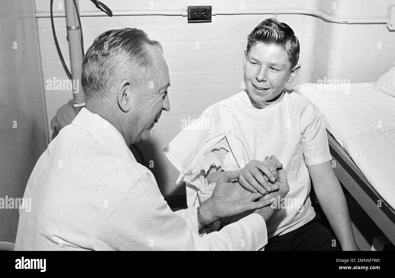 Everett Knowles, 13, grins despite pain as Dr. Arthur L. Watkins ...
