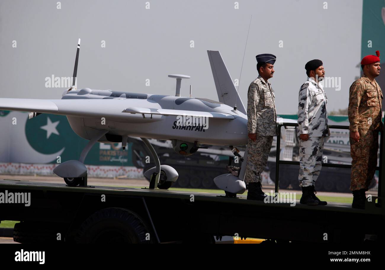 Pakistani soldiers stand beside a manufactured armed drone aircraft ...